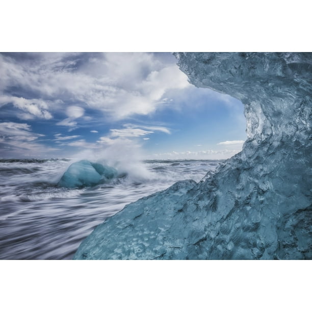 Blue ice and icebergs with water splashing at Jokulsarlon, South coast; Iceland by Robert Postma ...