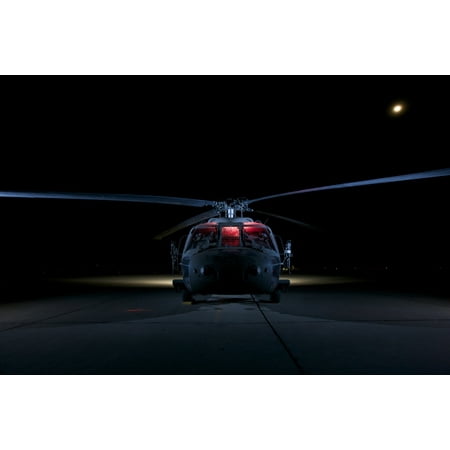 A UH-60 Black Hawk helicopter lit up by multiple external flash units ...