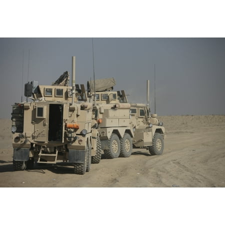 U.S. Army Cougar MRAP vehicles parked overlooking the top of a wadi ...