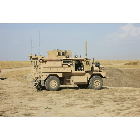 A U.S. Army Cougar MRAP vehicle parked overlooking the top of a wadi ...