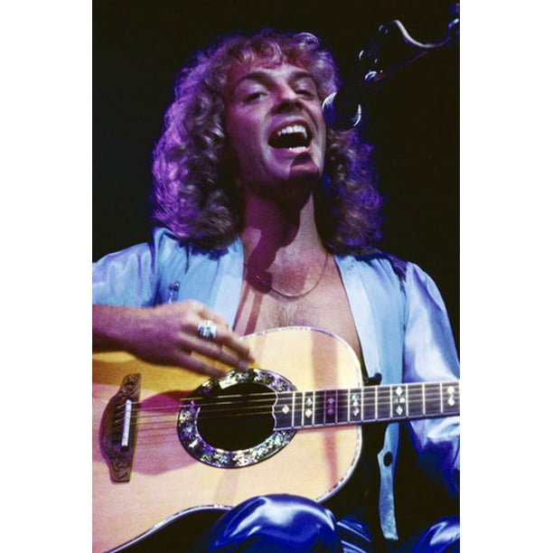 Peter Frampton 1970's concert pose in open blue shirt playing guitar ...