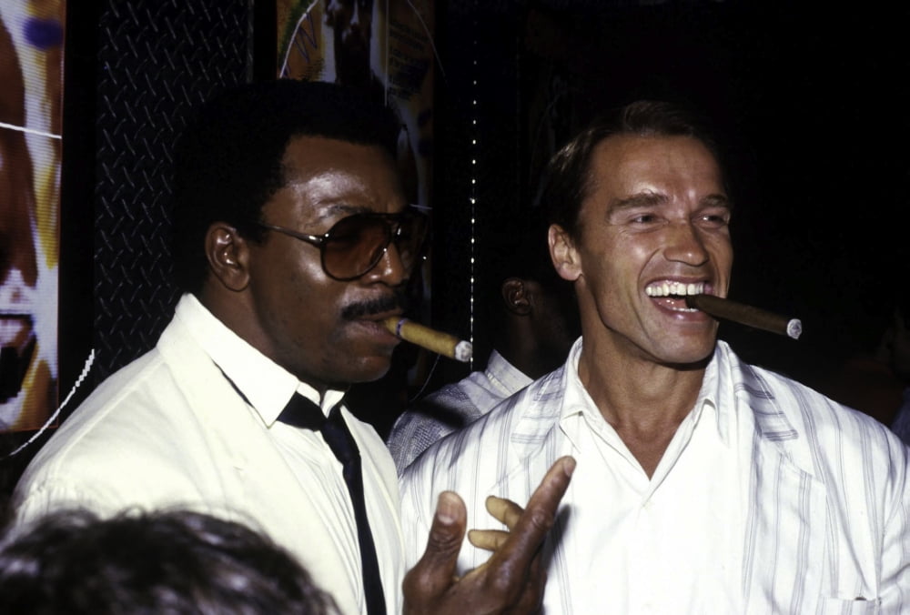 Arnold Schwarzenegger And Carl Weathers Smoking Cigars Photo Print
