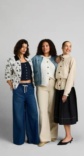 Three women pose wearing a mix of denim and canvas jeans, pants, and jackets featuring solid and floral prints.