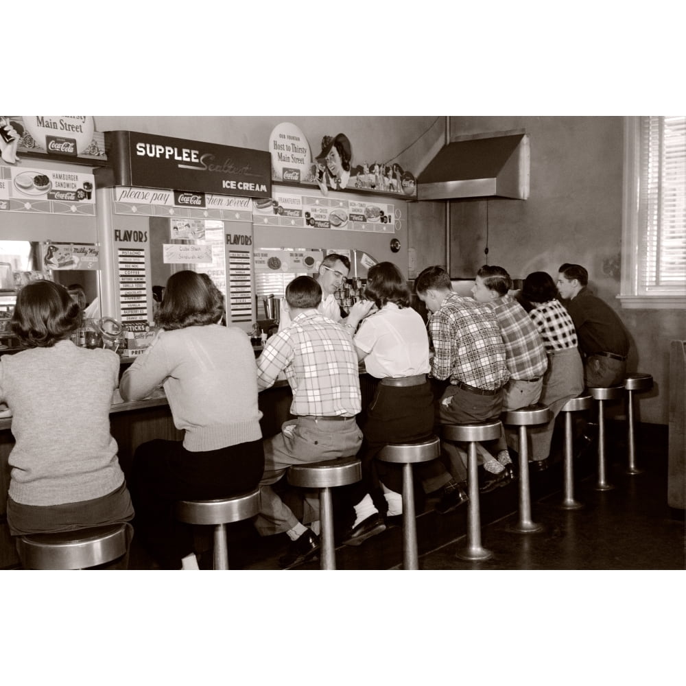 1950s Rear View Of Group Of Teenage Boys and Girls Sitting Together At ...