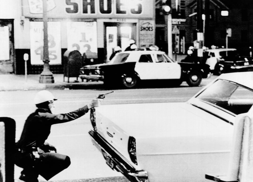 1965 Watts Riots. A Policeman Aims His Revolver At Building Where A ...