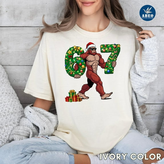 67 Bigfoot Festive Lights Tee, Strong Sasquatch Character with Decorated Numbers & Gifts Graphic ...