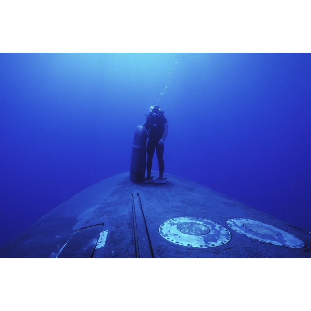 A Navy SEAL stands next to the sonar dome on the bow of the USS ...