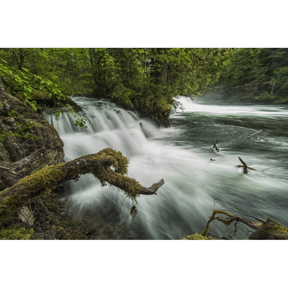 A river flows over a small waterfall in Nisgaa Memorial Lava Bed ...