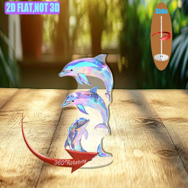 A rotating acrylic ornament featuring three iridescent crystal dolphins ...