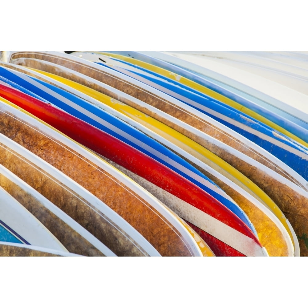 A stack of colourful longboard surfboards placed on the beach ; Waikiki ...