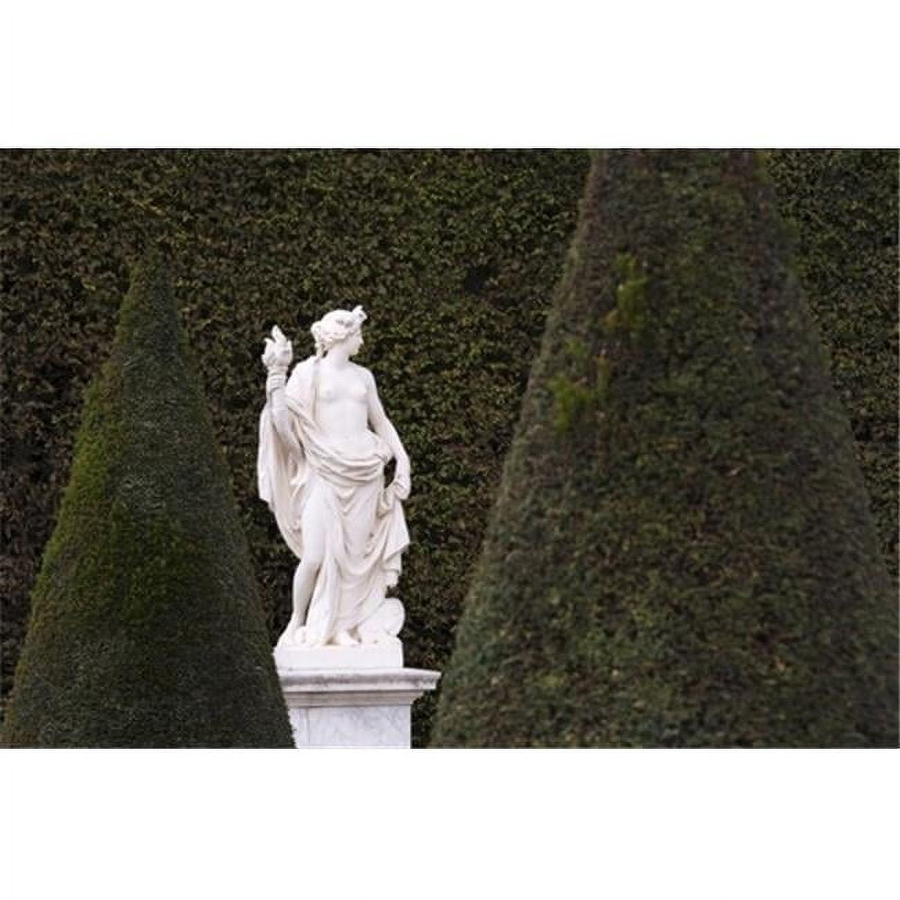 A white marble statue is shown against the green of a tall hedge in the ...