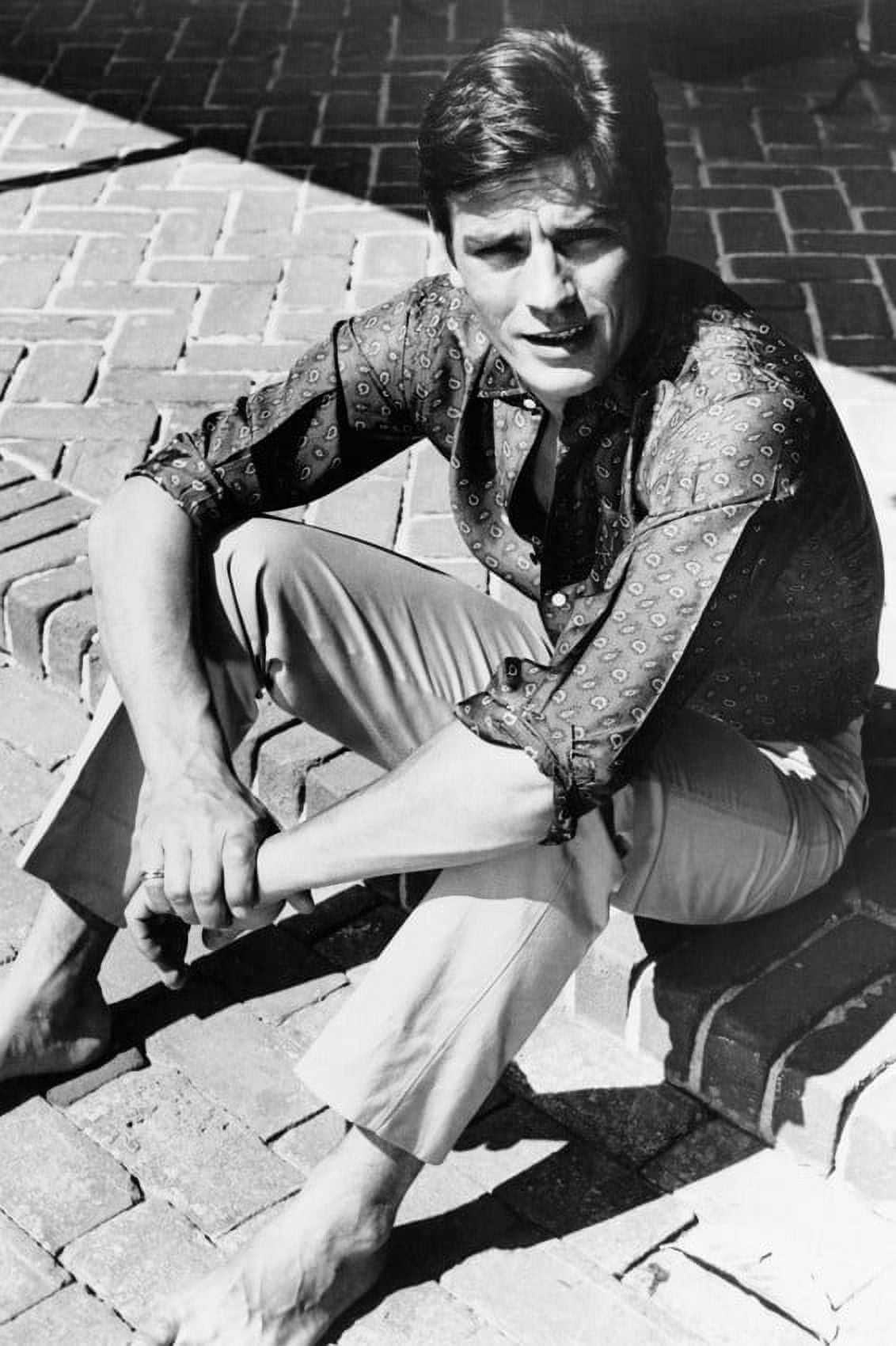 Alain Delon classic 60's barefoot in shirt and pants seated on steps ...