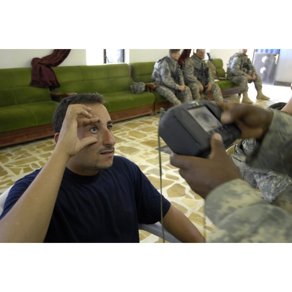 An Iraqi Candidate For The Sons Of Iraq Security Force Holds His Eye ...