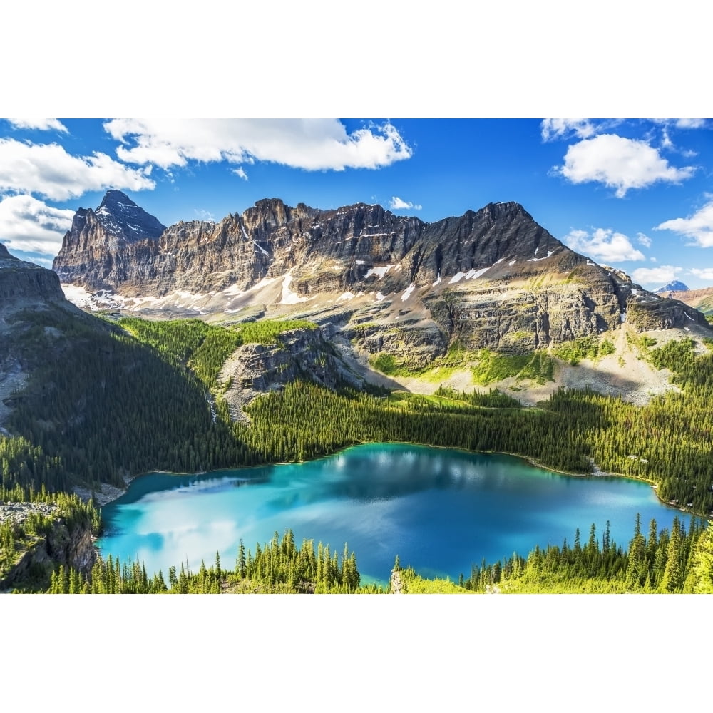 Beautiful blue alpine lake with rugged mountain in the distance with ...