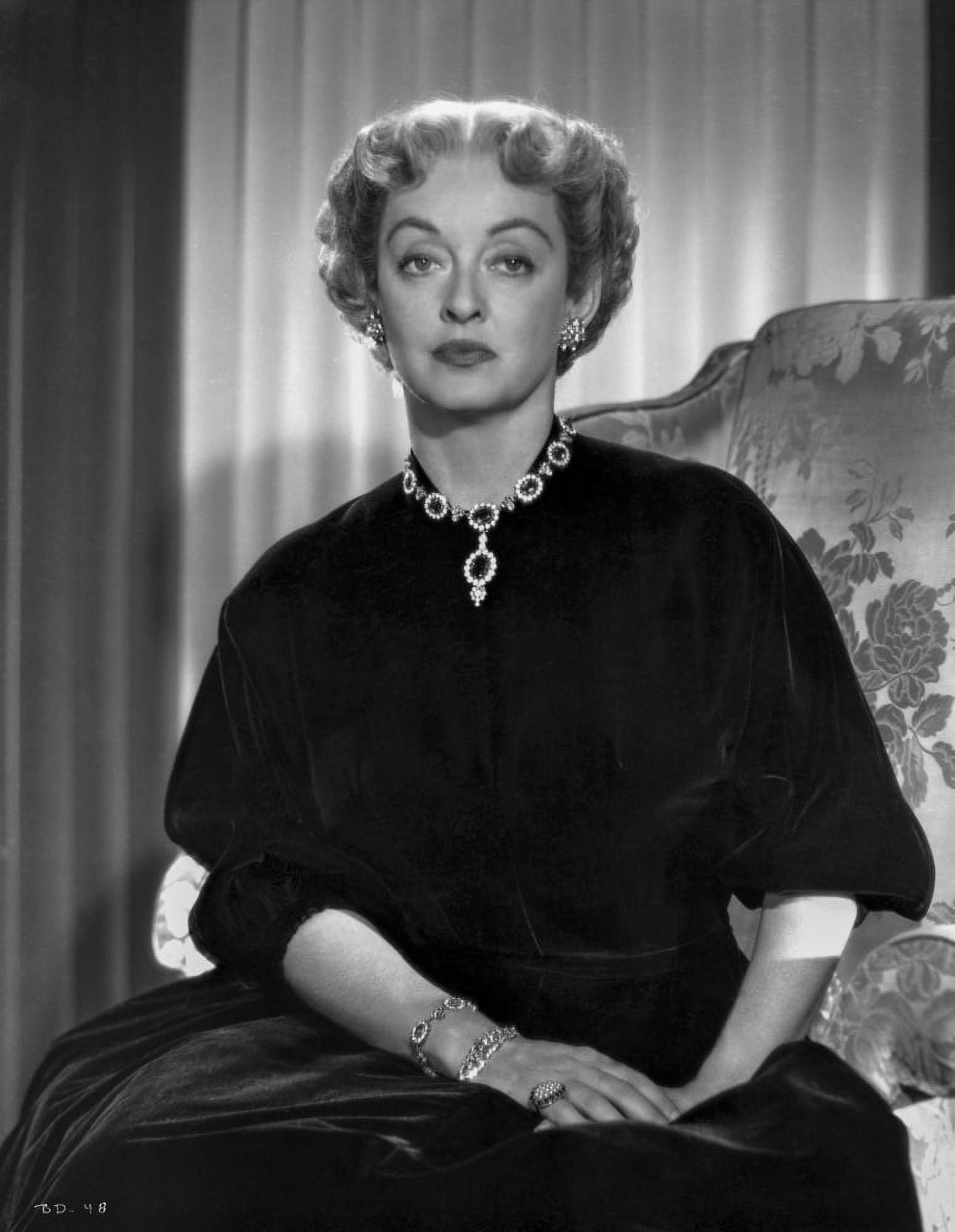 Bette Davis Seated on a Couch with Hands Together Laid on the Lap in ...