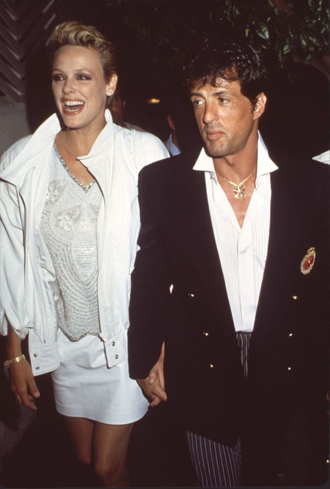 Brigitte Nielsen In White Skirt And Jacket And Sylvester Stallone In ...