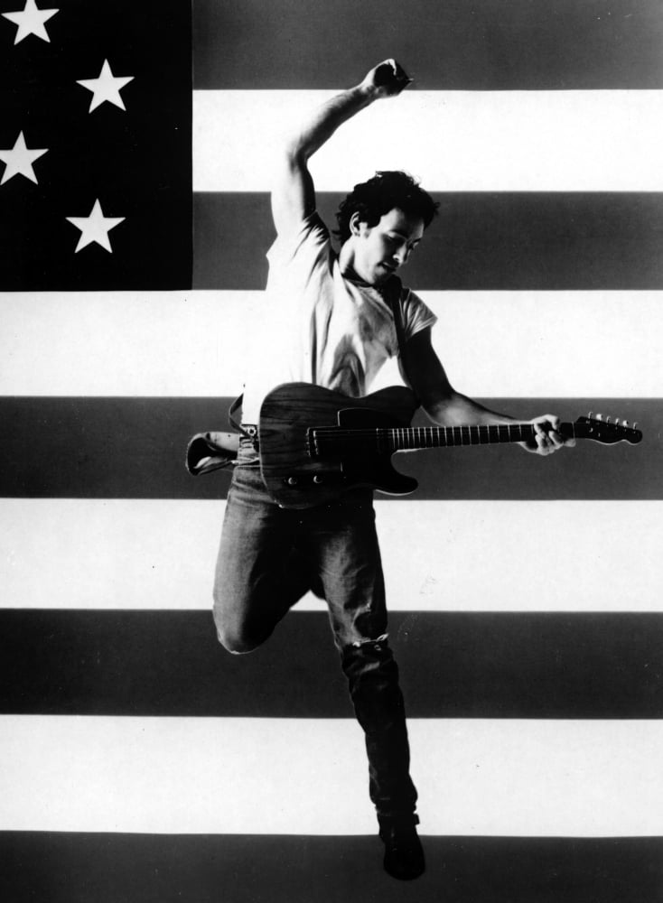 Bruce Springsteen playing guitar in front of an American flag Photo ...