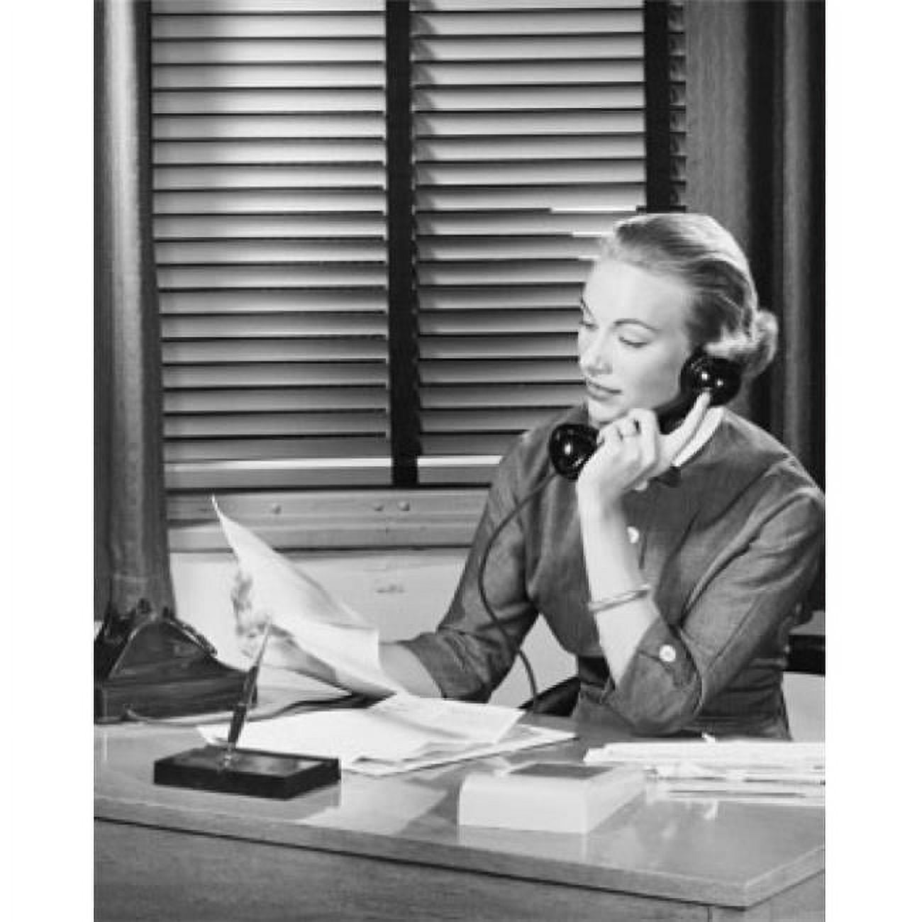Businesswoman Talking on the Telephone & Reading a Document in an ...