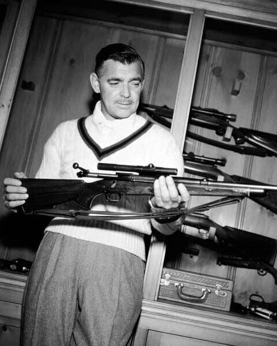 Clark Gable displays his gun collection in cabinet Poster 24x30 inches ...