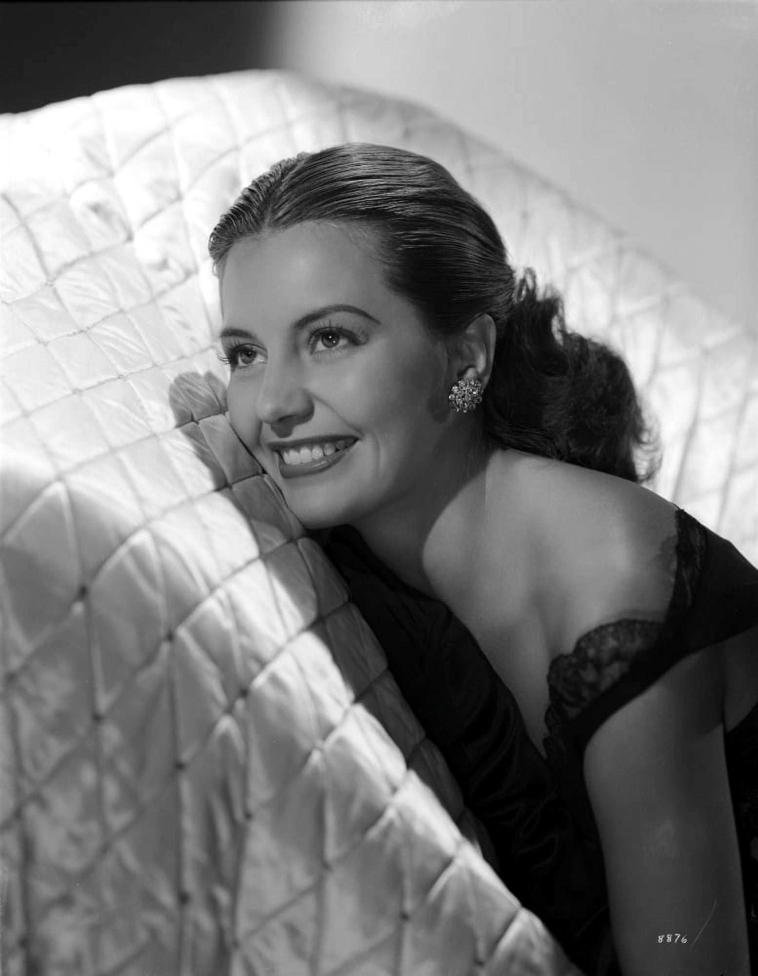 Cyd Charisse smiling in a White Couch wearing Black Sleeveless Dress ...