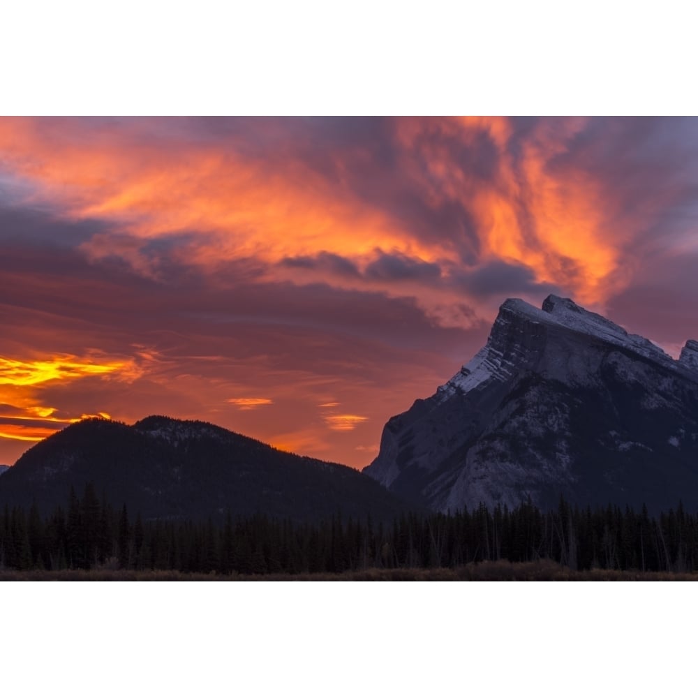 Dramatic glowing clouds over the rugged peaks of the Rocky mountains in ...