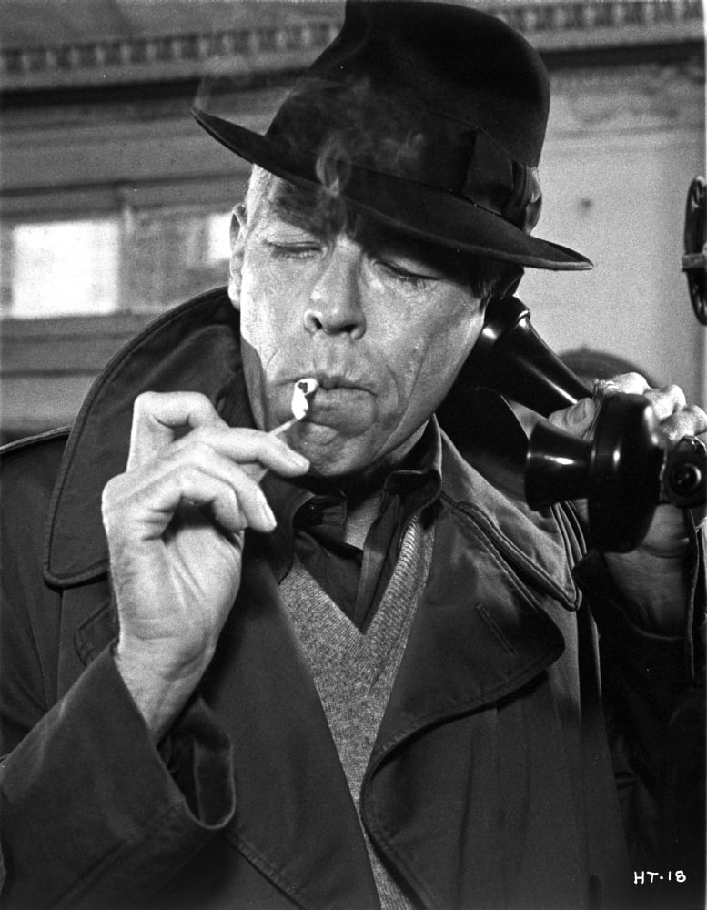 Film still of James Coburn smoking a cigarette and talking on the ...
