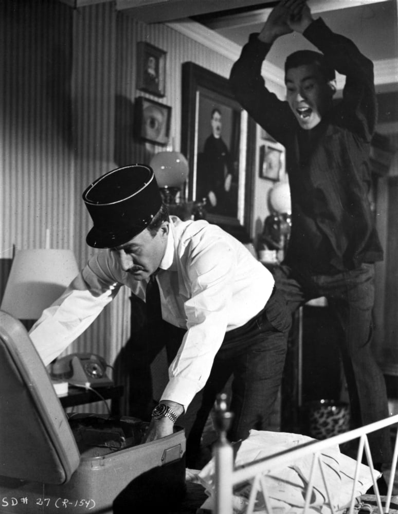 Film still of Peter Sellers as Inspector Clouseau with a man behind him ...