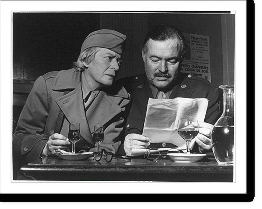 Historic Print, [Janet Flanner and Ernest Hemingway, both in uniform, seated reading papers at a ...
