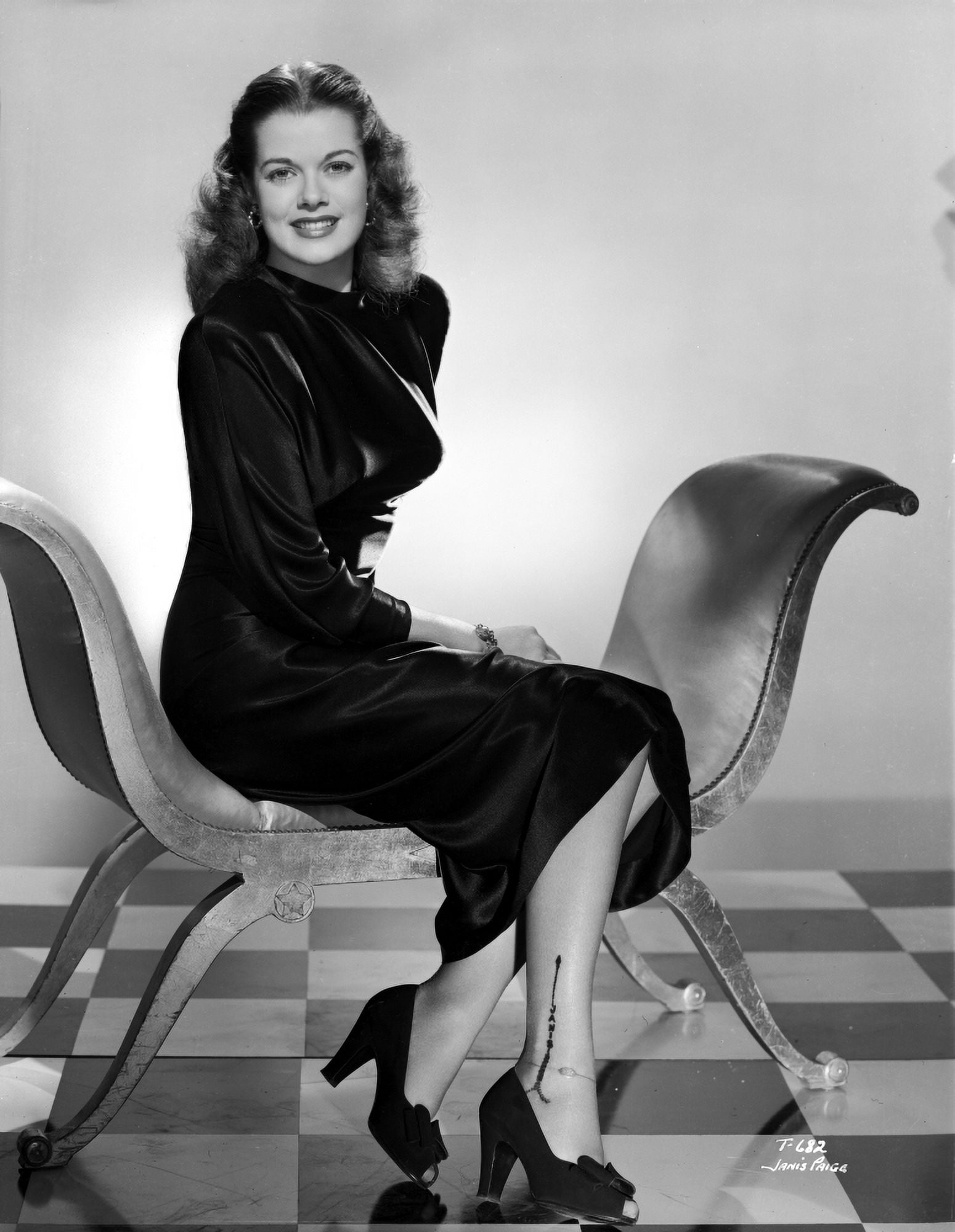 Janis Paige sitting on a Chair in Black High-Neck Long Sleeve Velvet ...