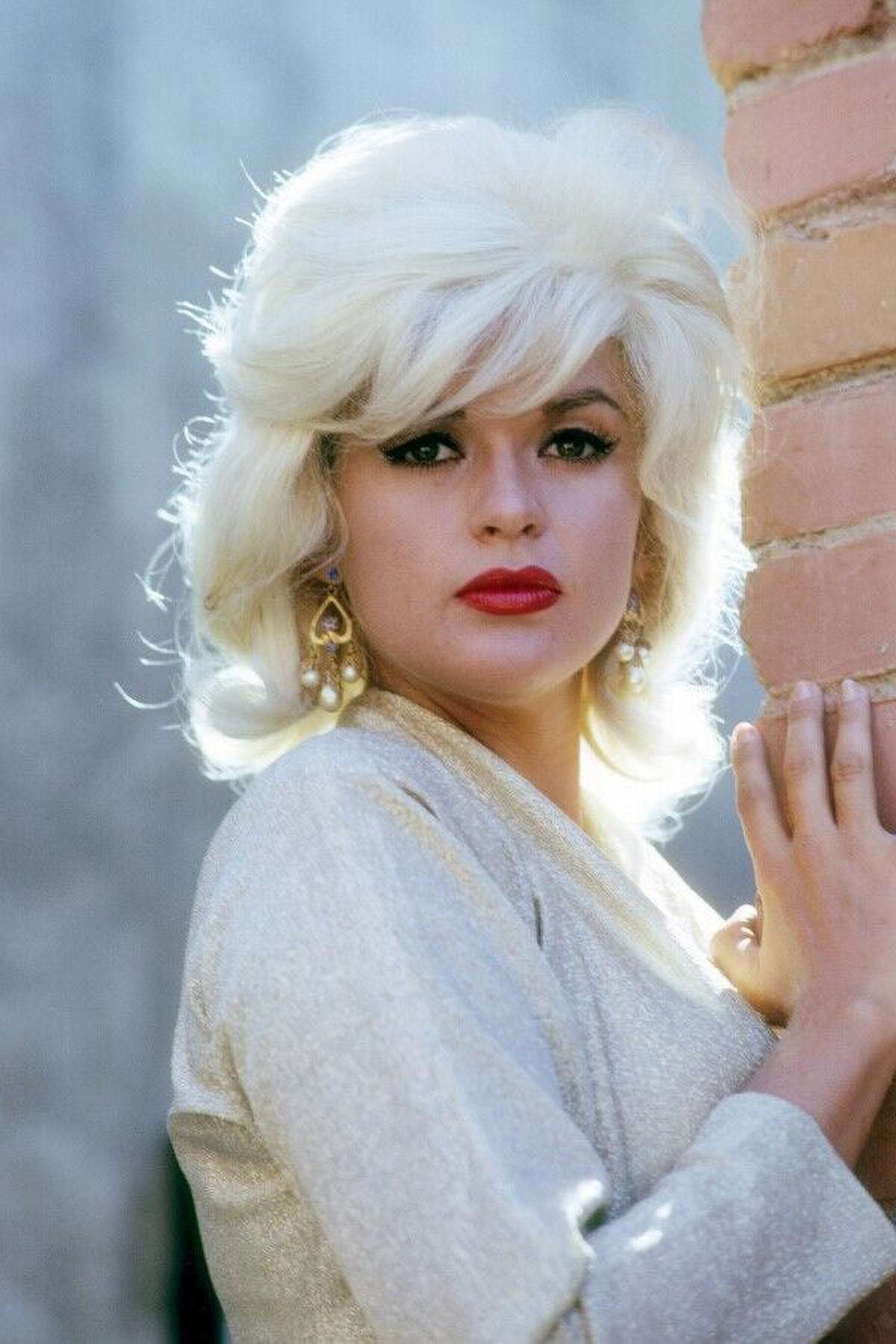 Jayne Mansfield stands next to brick wall in grey jacket 8x10 photo ...