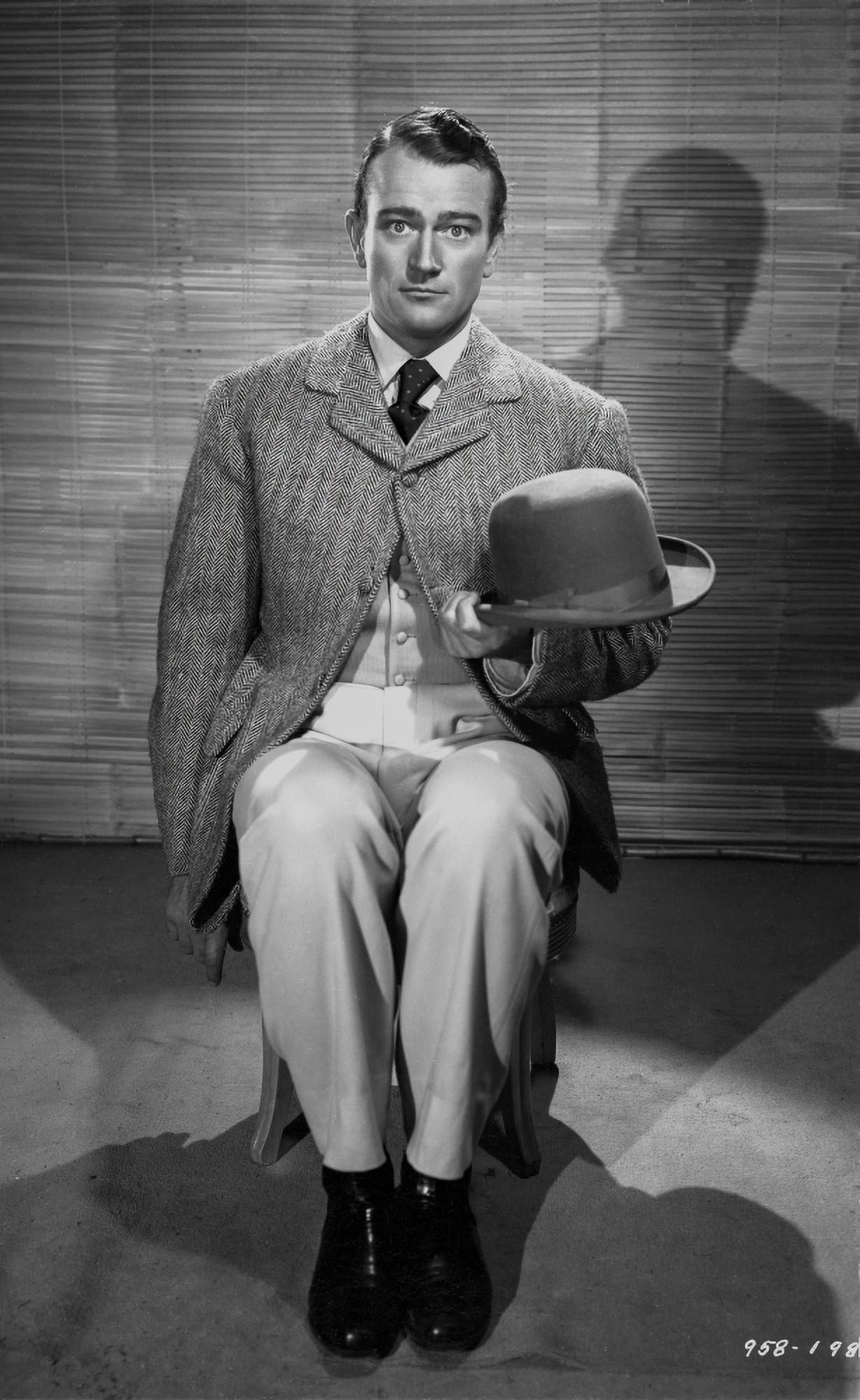 John Wayne sitting on a Chair and Holding His Hat Photo Print (24 x 30 ...