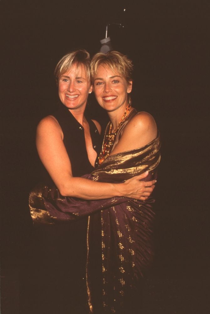 Kelly Stone In Black Dress Hugging Sharon Stone In Gold Outfit At ...
