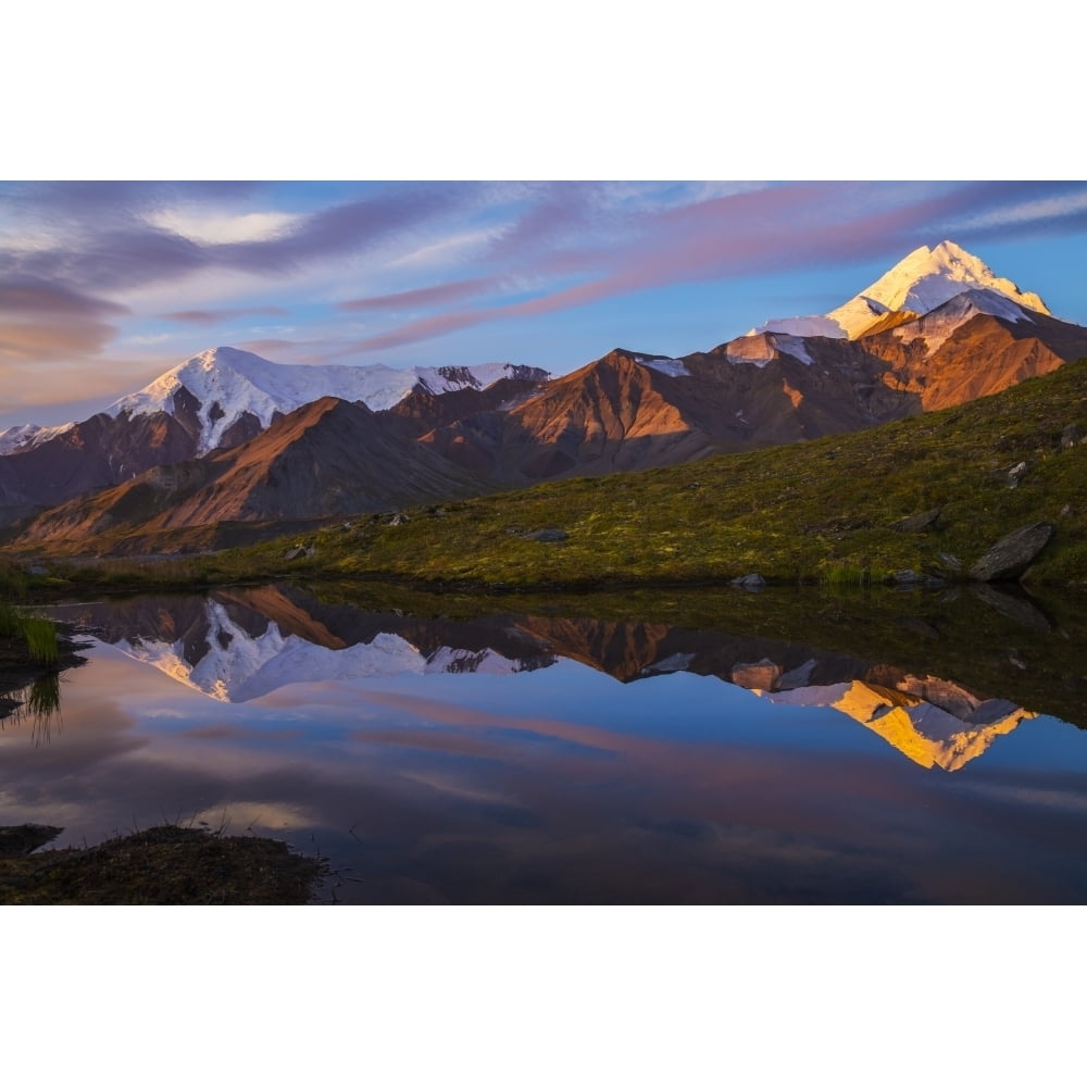 Mount Hayes reflects in a pond at sunrise viewed from a remote area ...