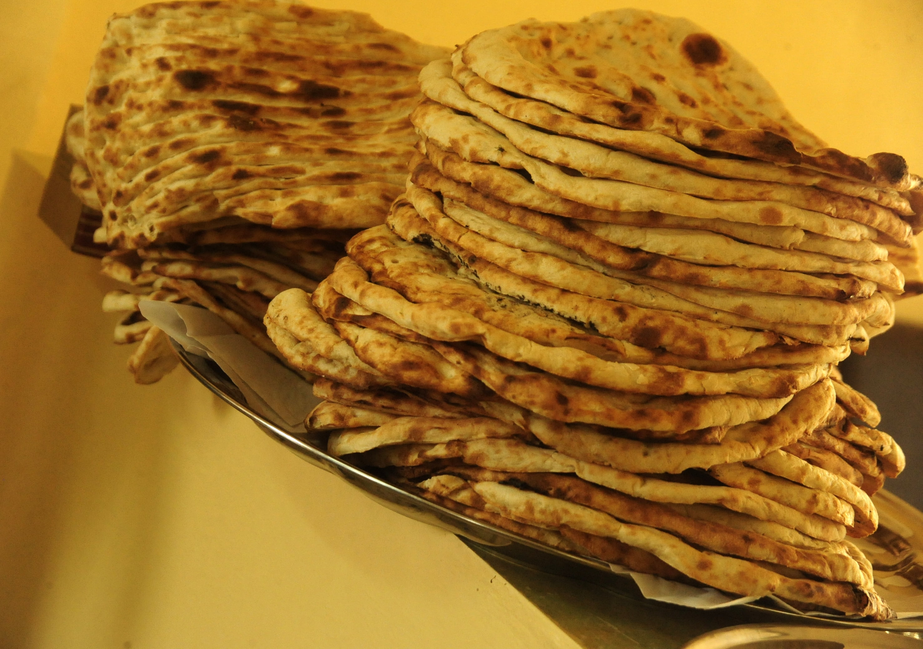 Naan bread, often eaten with traditional Afghan meals, is prepared for ...