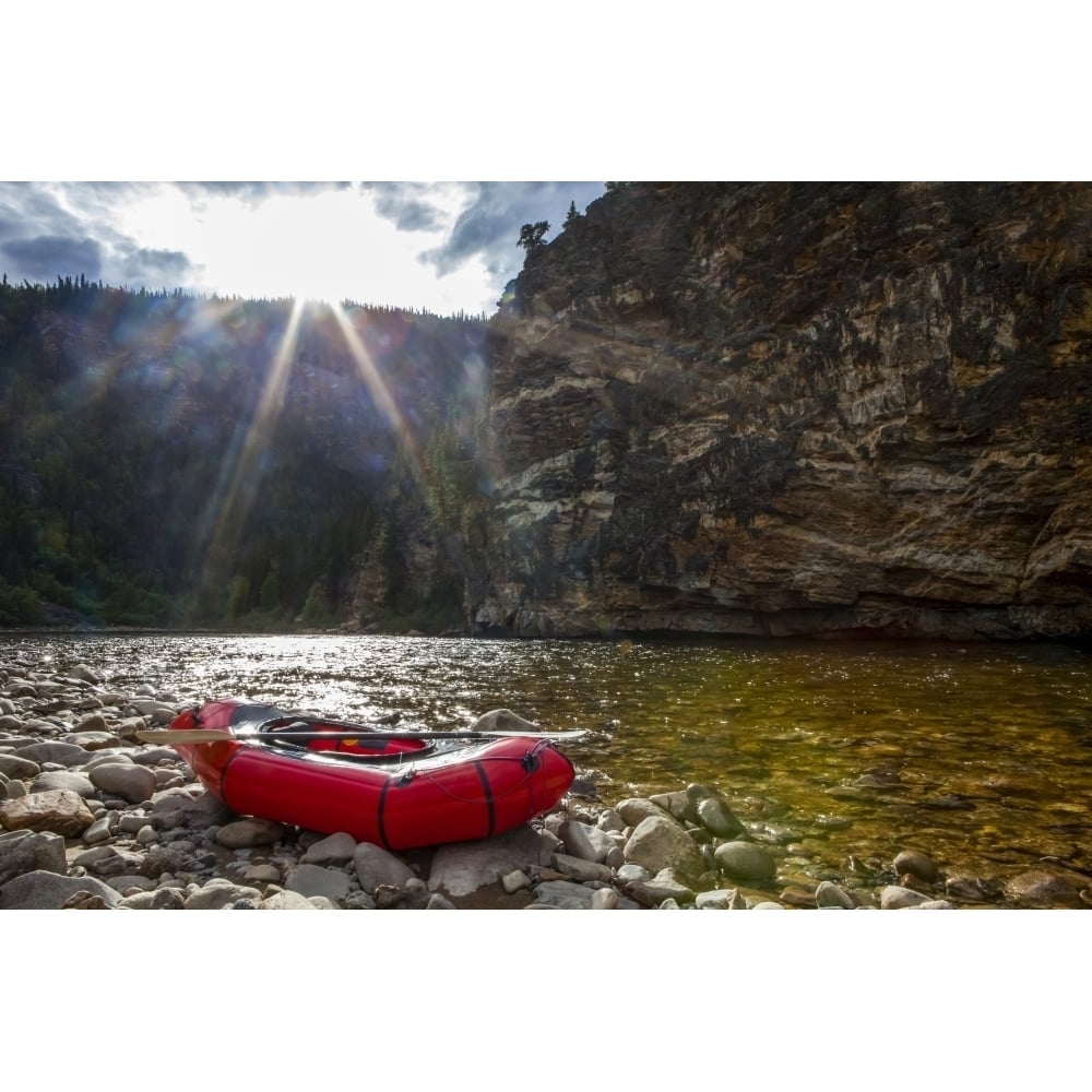 Packraft on the banks of the Charley River sun going down behind ridge ...