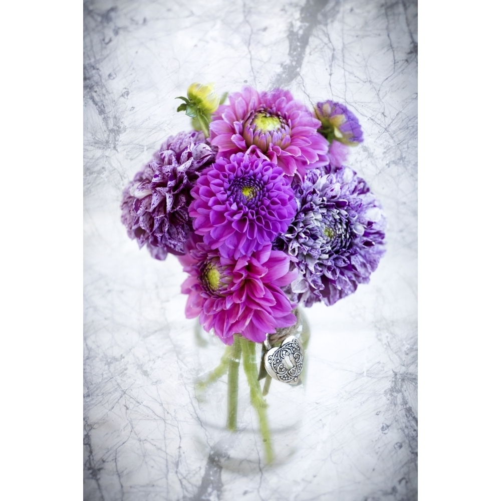 Purple marbled dahlias arranged in a glass jar on a marble counter by ...