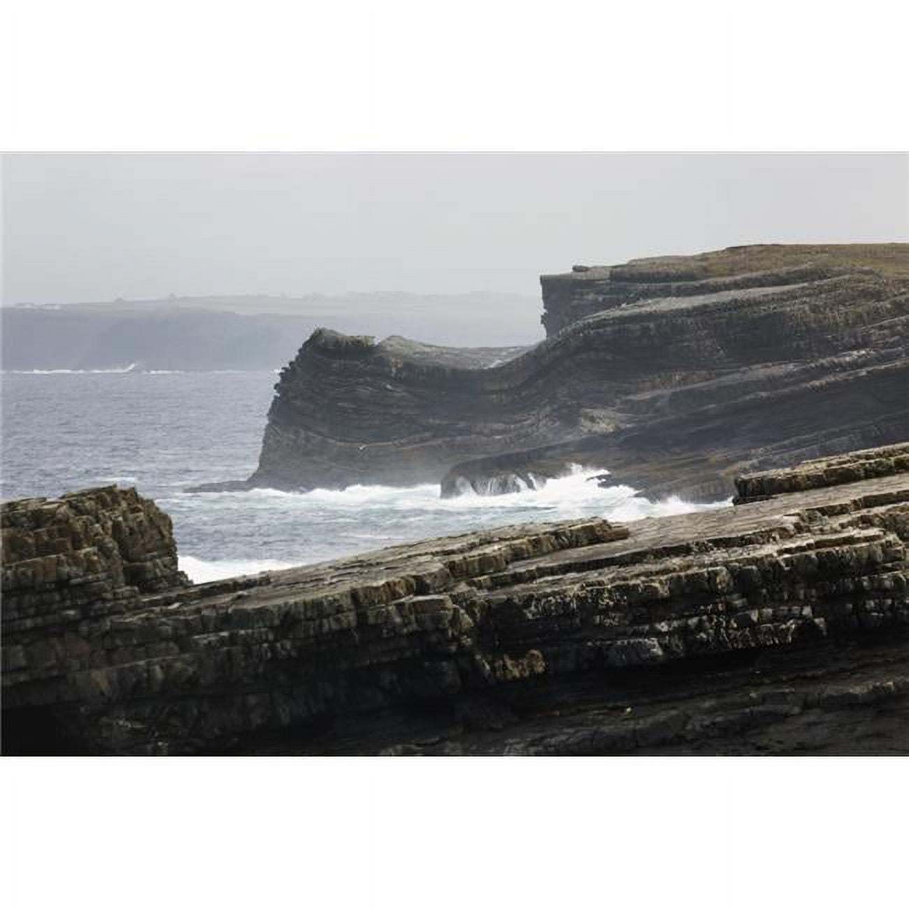 Rugged dark rocky cliffs with waves and fogged sky; Kilkee County Clare ...