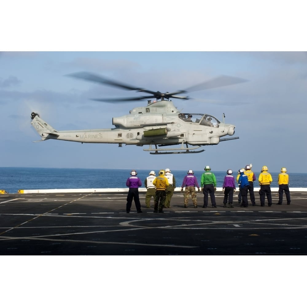 Sailors and Marines watch an AH-1Z Viper attack helicopter lift off the ...