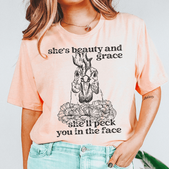 Shes Beauty And Grace Shell Peck You In The Face Tee Heather Prism ...