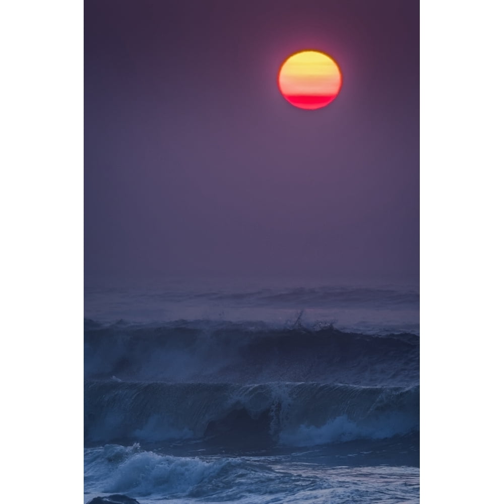 Smoke in the air colors the sun on a summer evening; Seaside Oregon ...