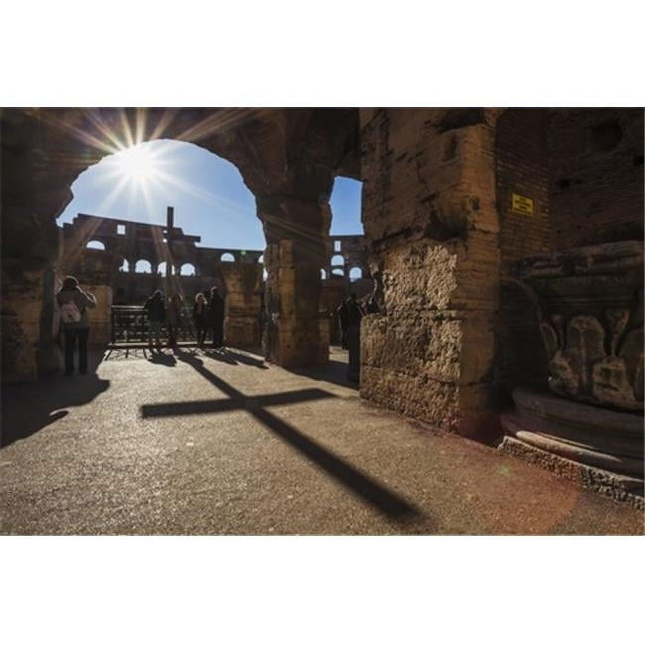 Sunburst through an archway at the Colosseum and a shadow of a cross ...