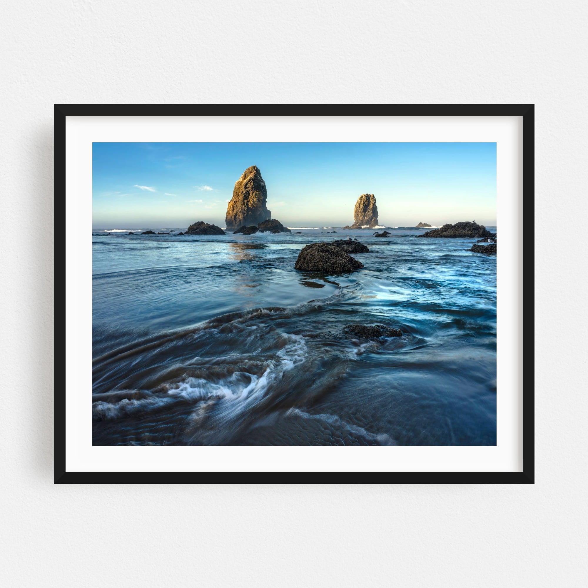 Tranquil waves flow around striking coastal rock formations - Cannon ...