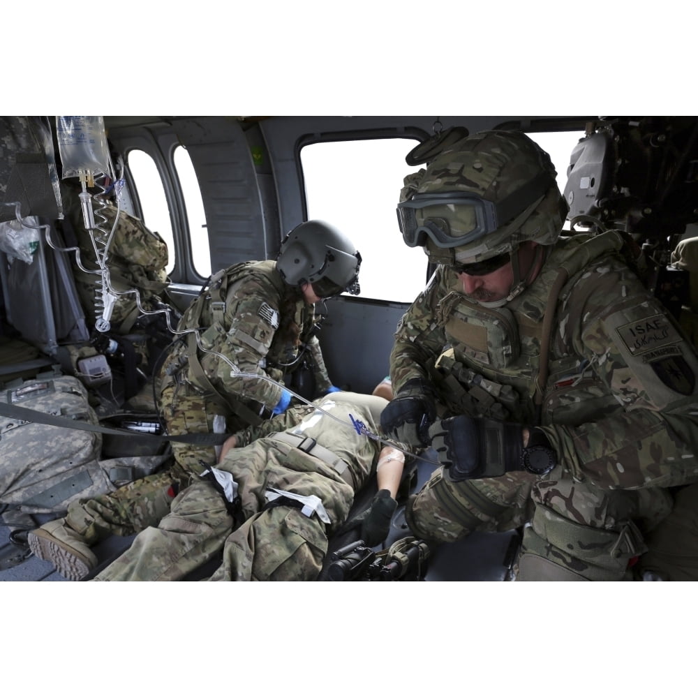 U.S. Army flight medics aid a simulated casulaty in a UH-60 Black Hawk ...