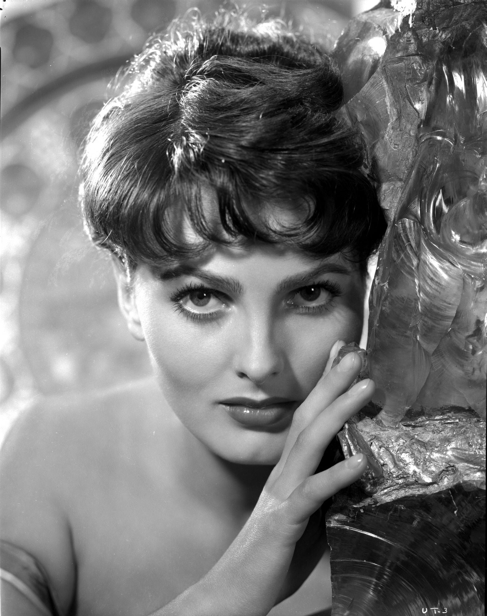 Ursula Theiss leaning with one hand on an intricately carved stone slab ...