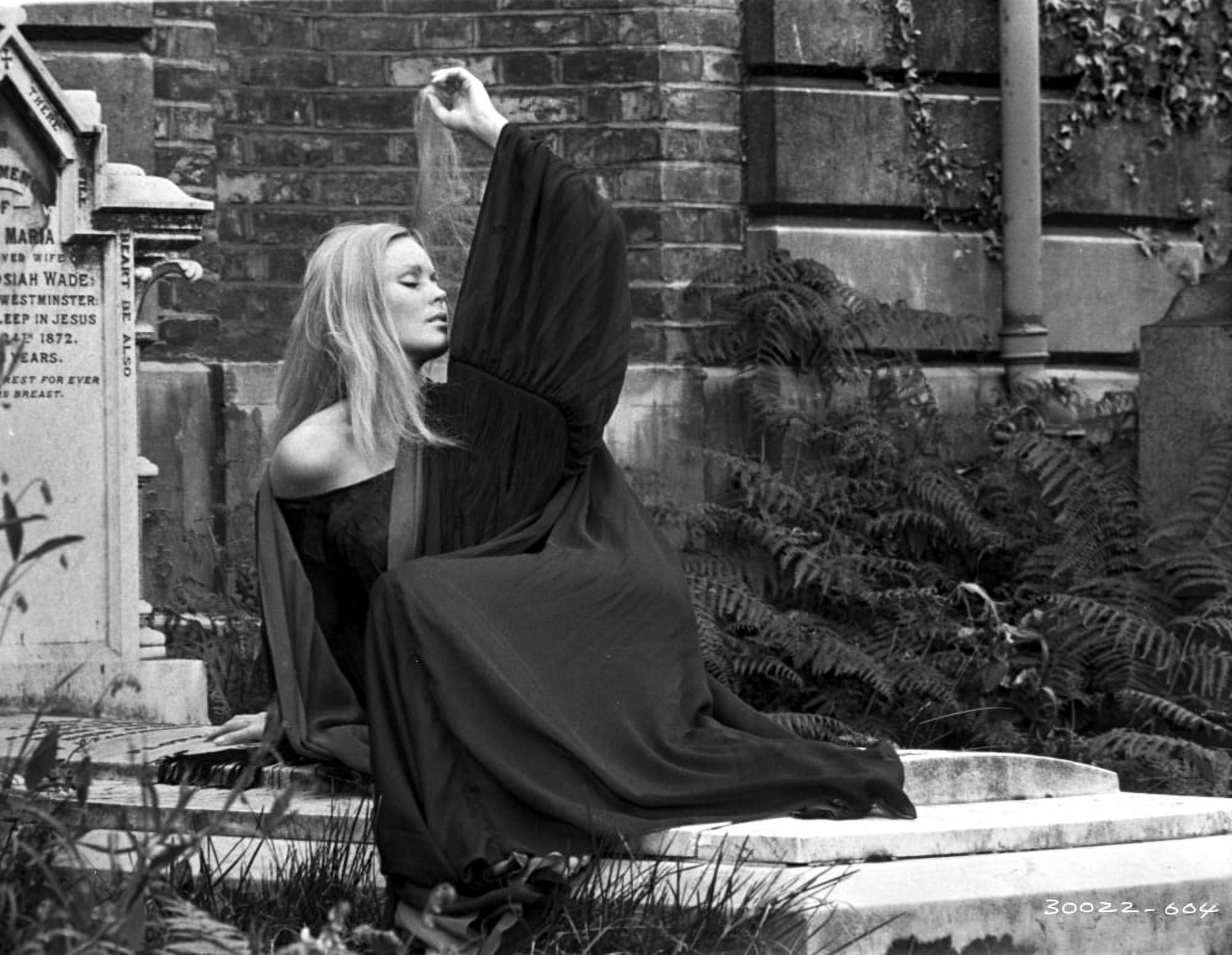 Veronica Carlson posed laying on concrete slab, with her arm raised and ...