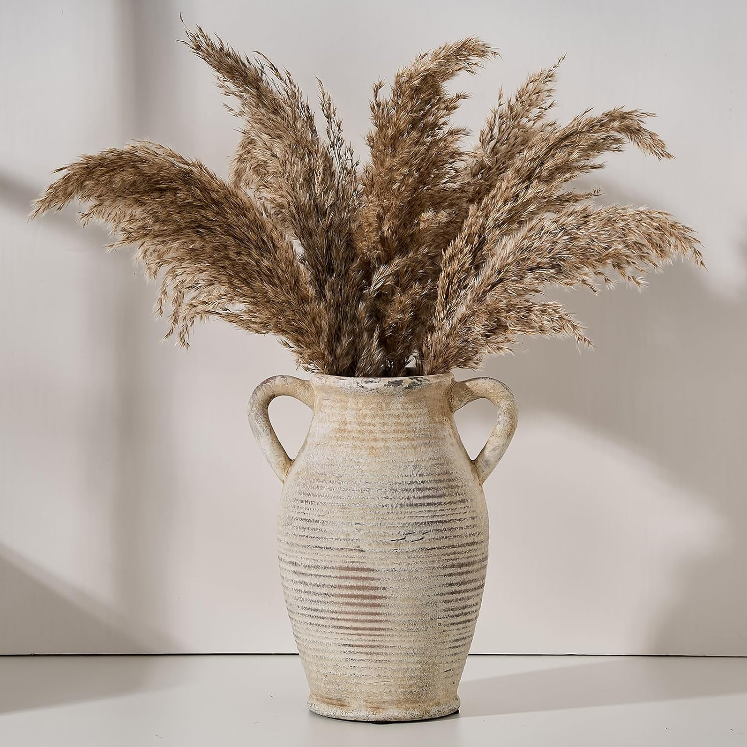 Vintage striped double eared ceramic vase paired with reeds, creating a ...