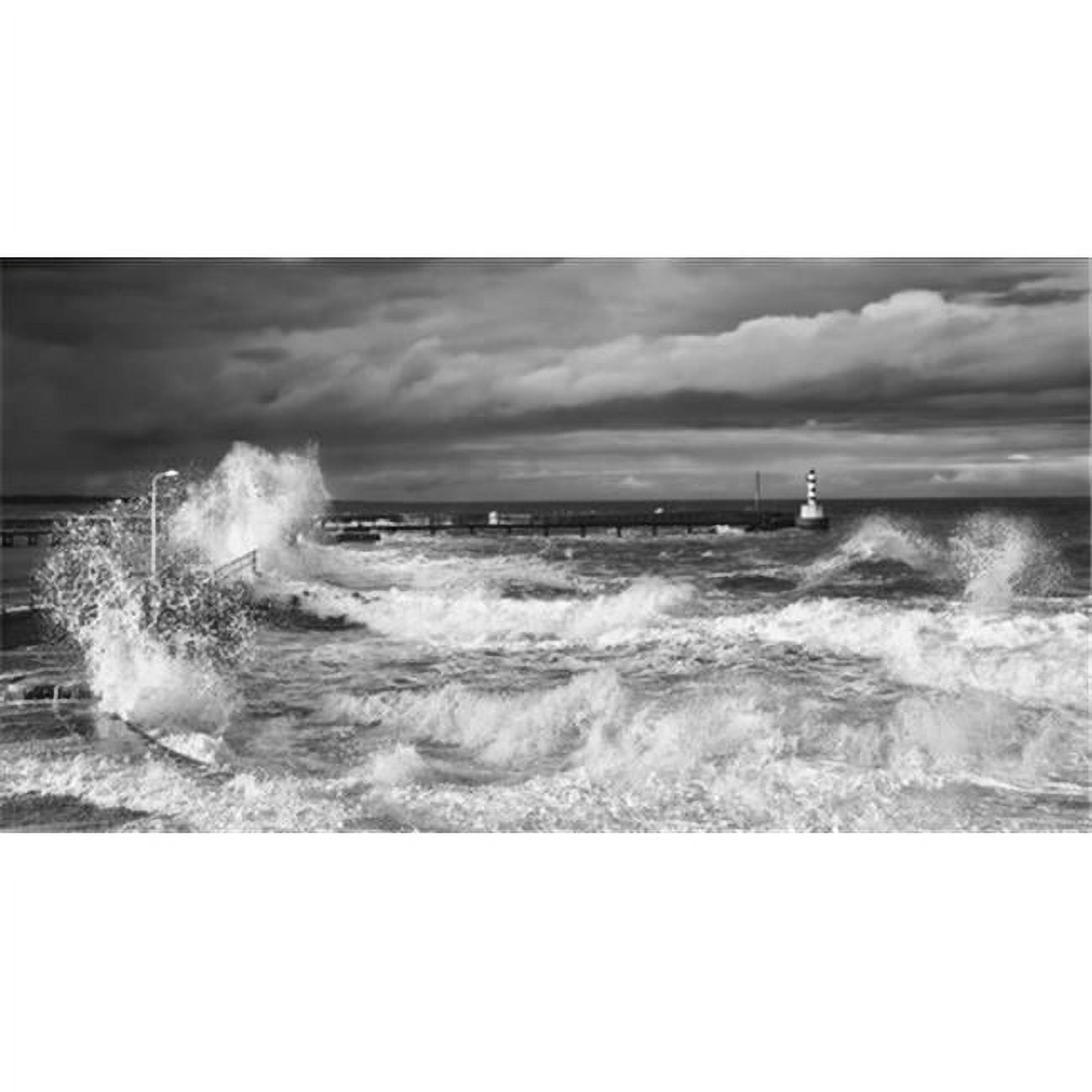 Waves crashing along the coast with a small lighthouse at the end of a ...