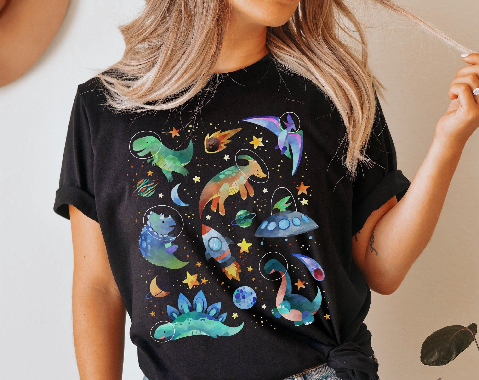 black tshirt with a colorful graphic print of dinosaurs in space The ...