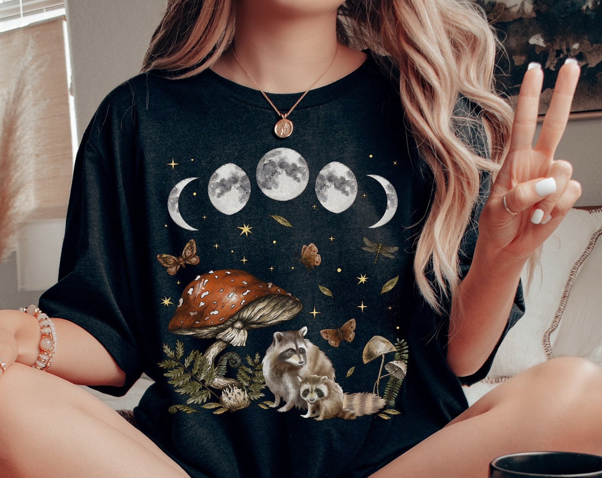 black tshirt with a graphic print of a raccoon and mushrooms under a ...