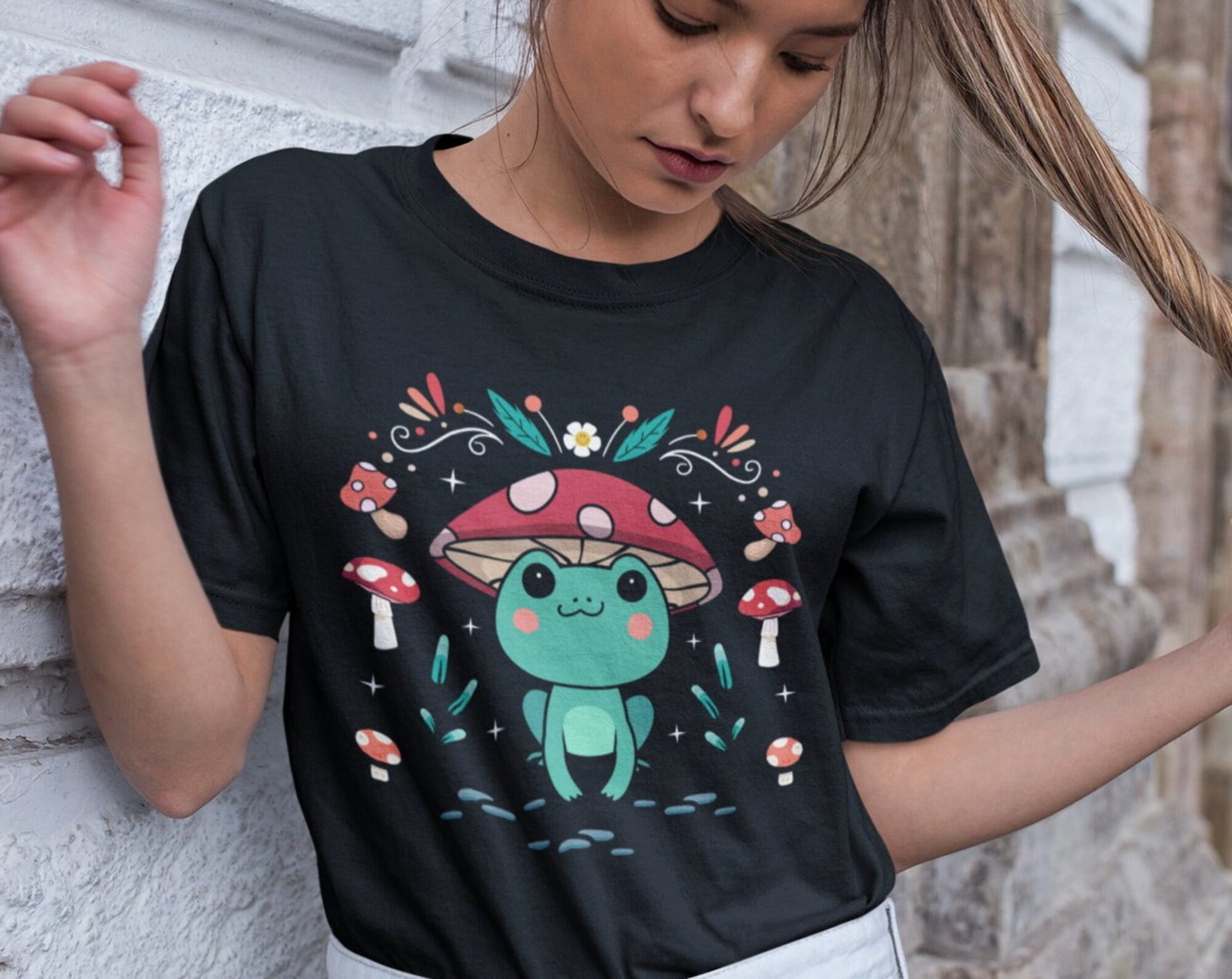 black tshirt with a green frog wearing a red and white mushroom hat The ...